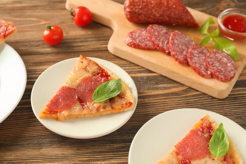 Plates with Pieces of Pepperoni Pizza on Table Stock Image - Image of ...