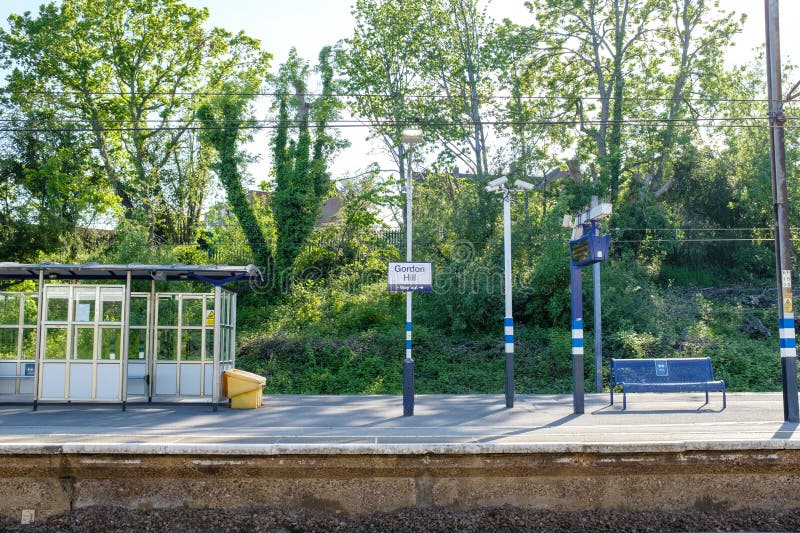 Train Platform at Gordon Hill Station, Featuring an Empty Blue Bench ...