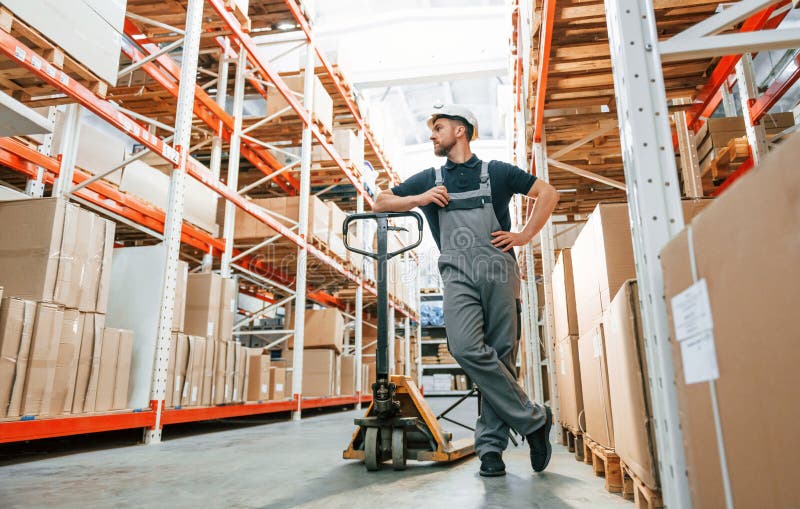 With Platform Trolley. Employee in Uniform is Working in the Storage at ...