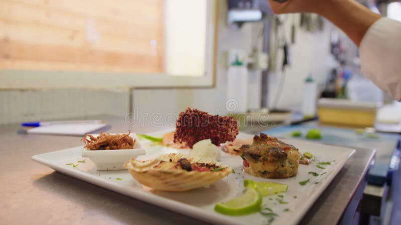 Plating of a Raw and Cooked Fish Based Appetizer in a Luxury Italian ...
