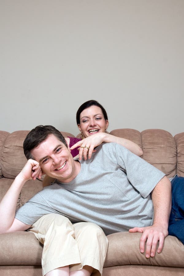 Playful Couple On The Couch - Vertical Stock Photo - Image of hugging ...
