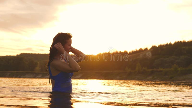 Playful Girl Splashes Her Long Hair In A Refreshing Summer Evening Near