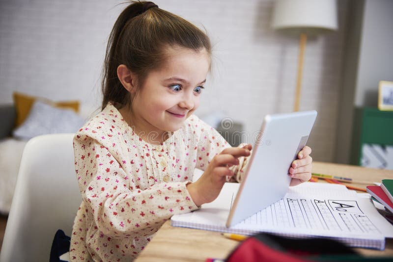 Playful Child Using a Tablet while Doing His Homework at Home Stock ...