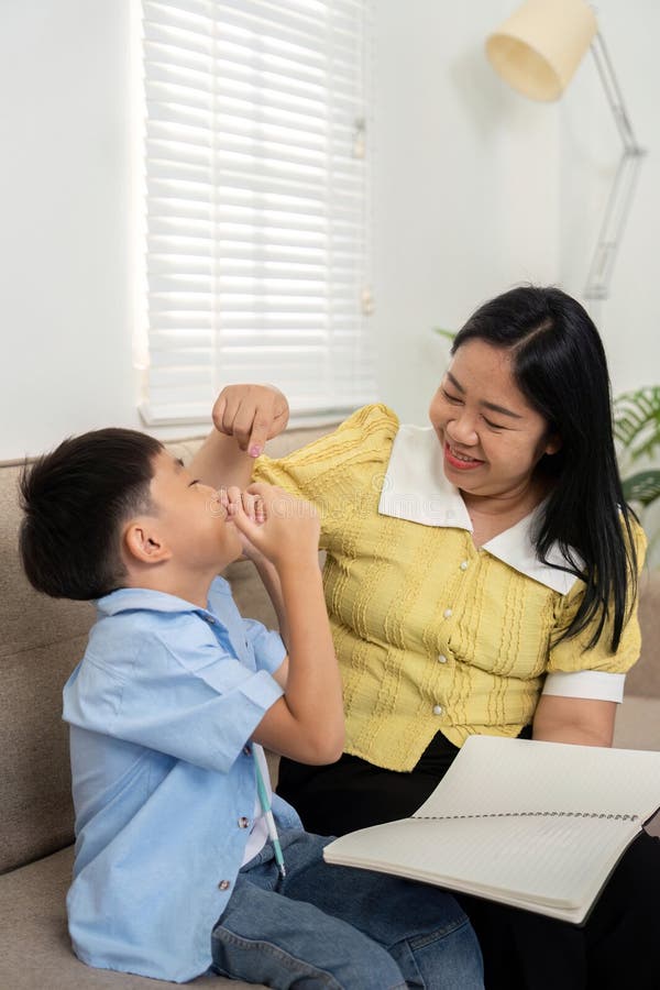 Mother and Son Playful Learning. a Mother Engages Her Son in a Fun Moment while Helping with ...