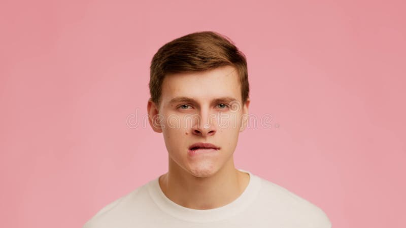 Playful Millennial Guy Biting Lips Posing Over Pink Background Stock ...