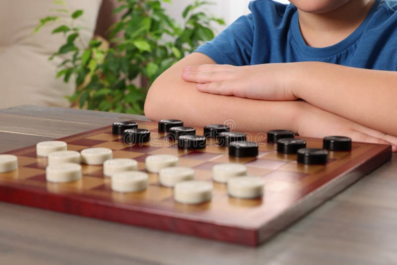 Playing Checkers. Boy Thinking about Next Move at Table in Room Stock ...