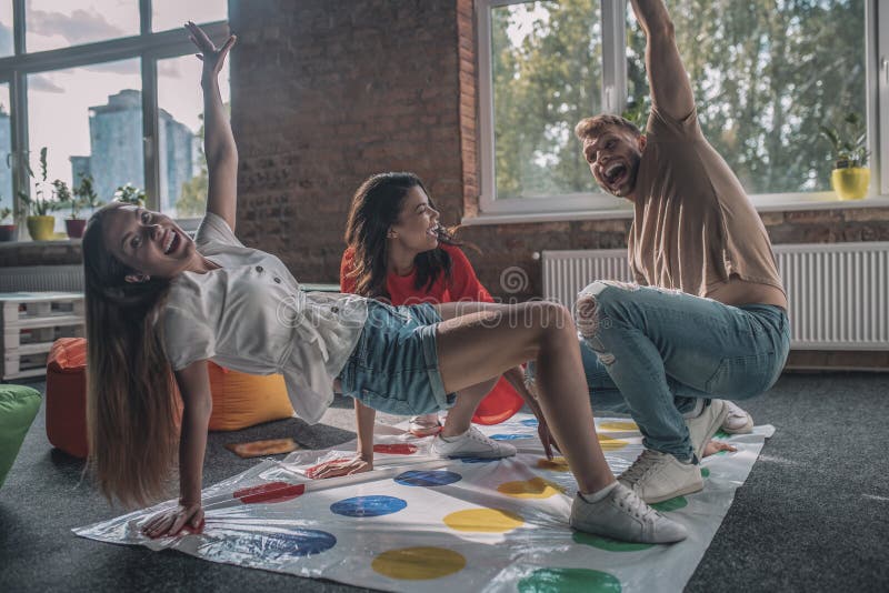 Three People Having Fun while Playing Twister Game Stock Image - Image ...