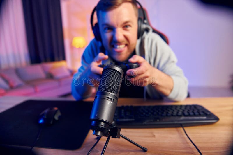 Playing the Game. Man in Headphones and with Microphone is Live on the ...