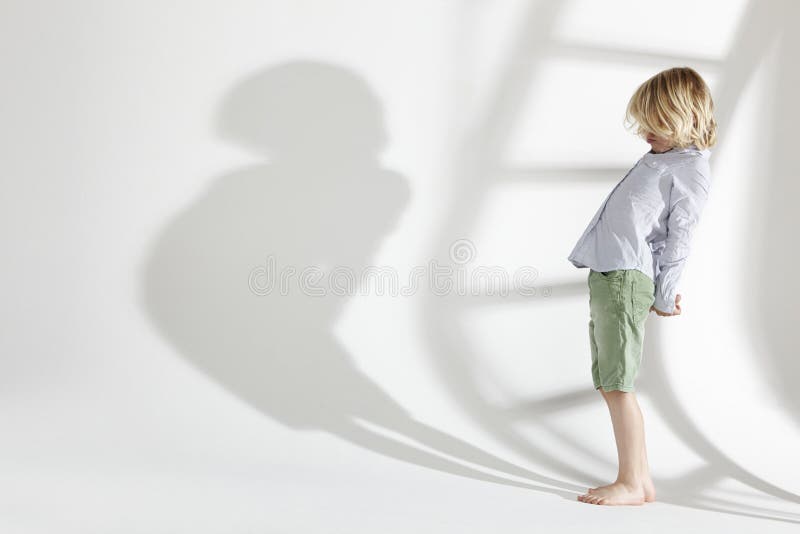 Playing with My Shadow. Studio Shot of a Young Boy Standing and Looking ...