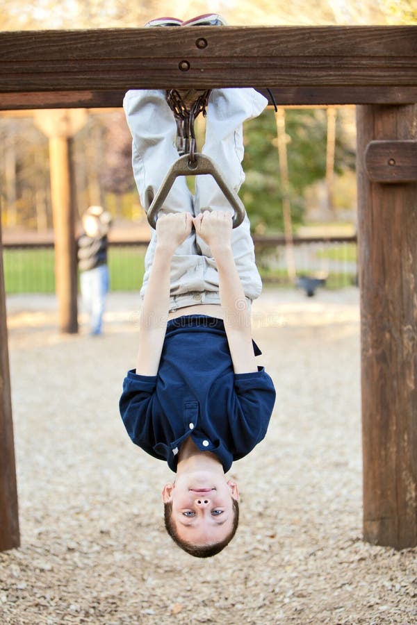 Boy Hanging Upside Down in Park Stock Image - Image of childhood, child ...