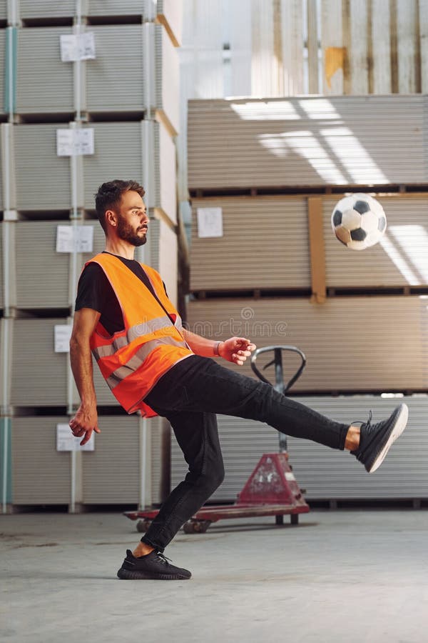 Playing Soccer. Storage Worker is in the Warehouse with Bunch of ...