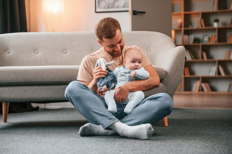 Playing by Using Soft Toy. Father with His Newborn Baby is Indoors ...