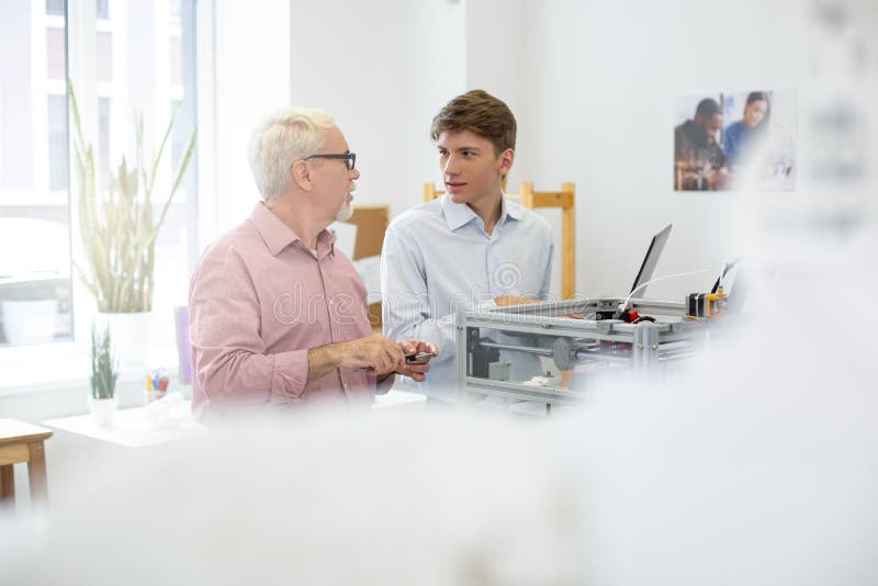 Senior Engineer Chatting with Intern while Using Caliper Stock Image ...