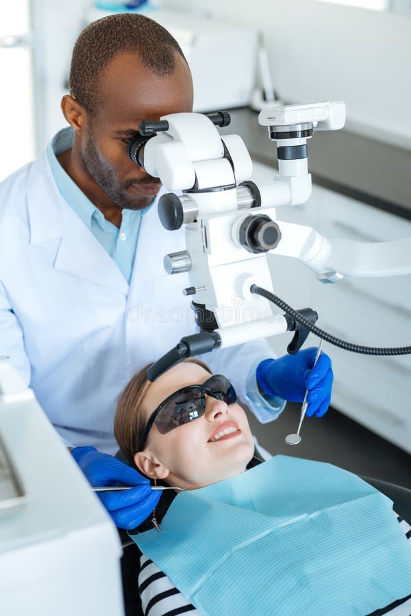 Pleasant Dentist Checking His Patients Teeth with Microscope Stock ...