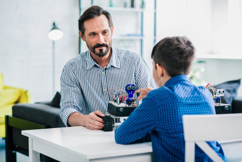 Pleasant Helpful Father Enjoying Robotic Engineering with His Son Stock ...