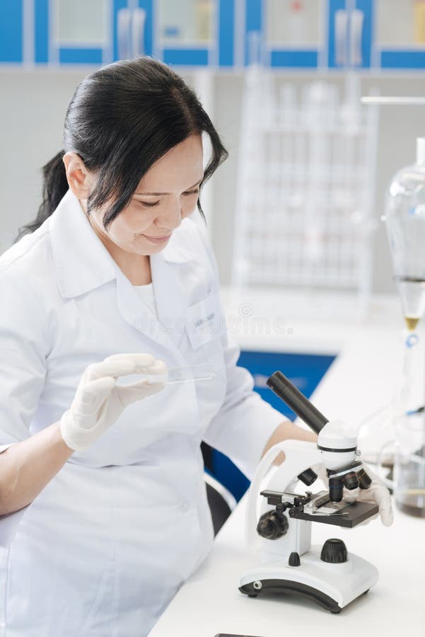 Pleasant Professional Biologist Holding a Microscope Slide Stock Photo ...