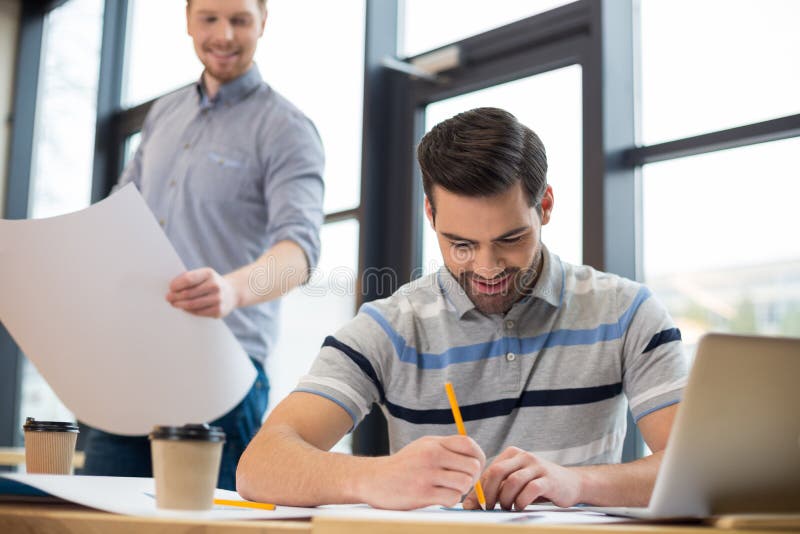 Pleasant Smart Man Doing a Drawing Stock Photo - Image of group, casual ...