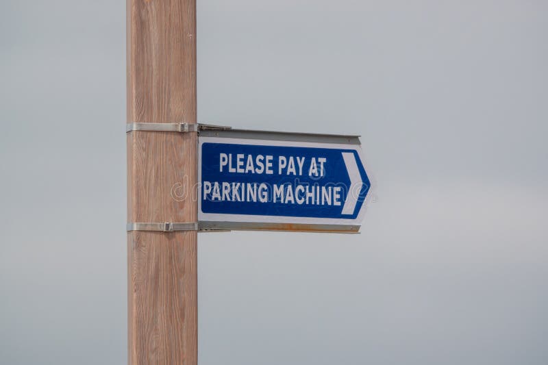 A Please Pay at Parking Machine Sign on a Wooden Post at a Car Park ...