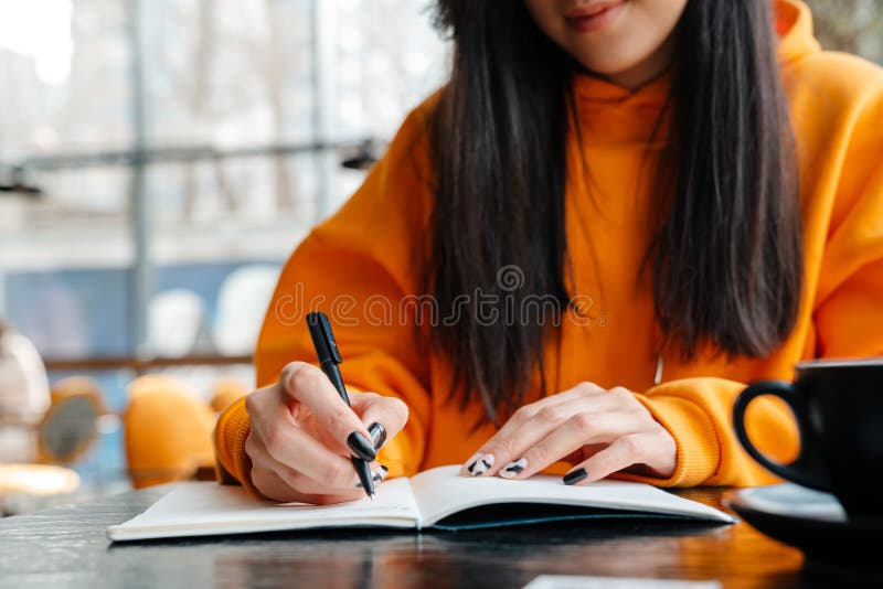 Pleased Asian Woman Writing Down Notes while Sitting Stock Image ...
