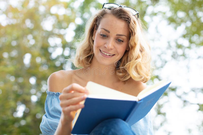 Pleased Woman Sitting on Bench and Reading Book in Park Stock Image ...