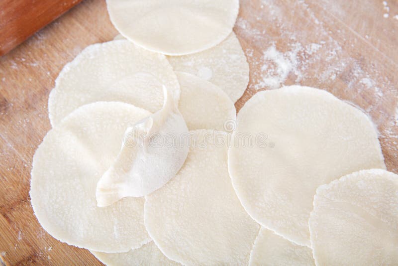 Plenty of Dumpling Skins and One Wrapped Dumpling on the Cutting Board ...