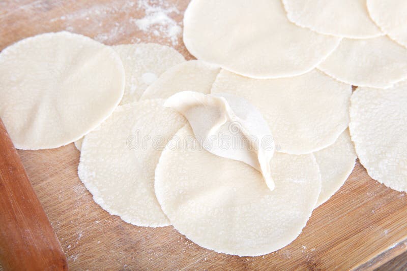 Plenty of Dumpling Skins and One Wrapped Dumpling on the Cutting Board ...