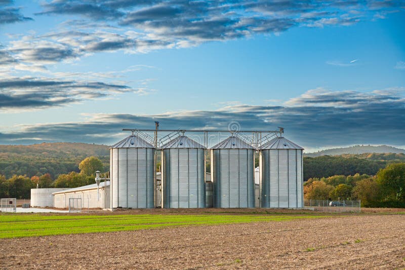 Plowed Field with Silver Silos and a Farmhouse at the Horizon Stock ...