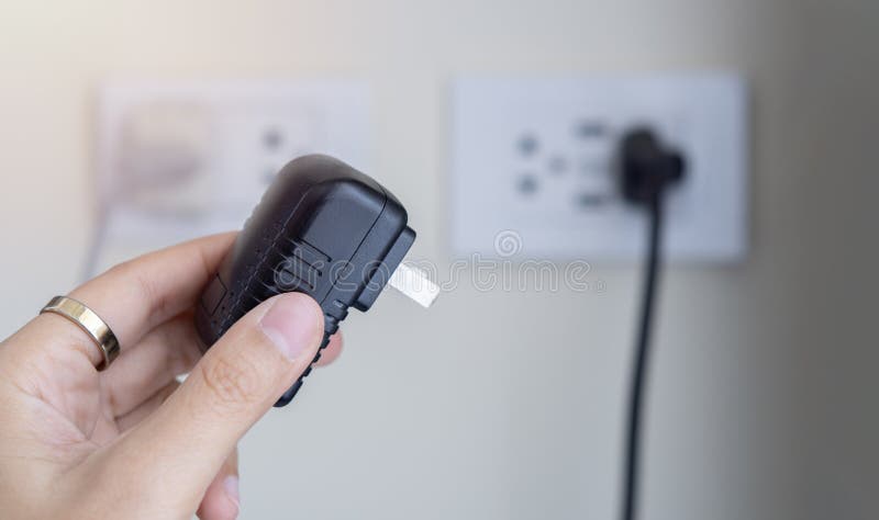 Plugging a Black Electrical Plug with a Woman S Hand into a White ...