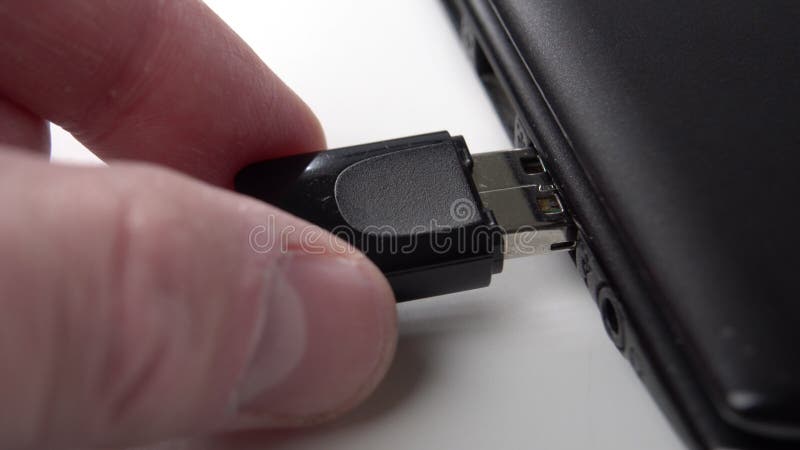 Plugging in USB Modem into Black Laptop Computer on a White Table ...