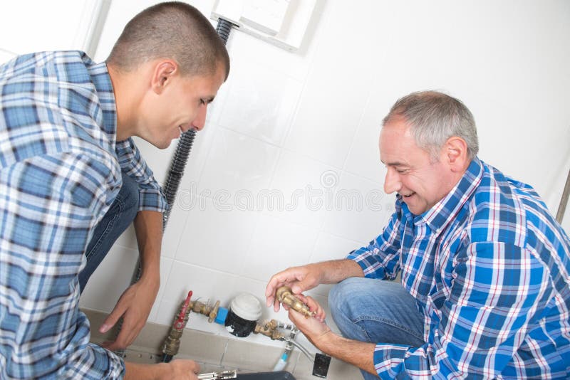 Plumber and Apprentice Fitting Central Heating Stock Photo - Image of ...