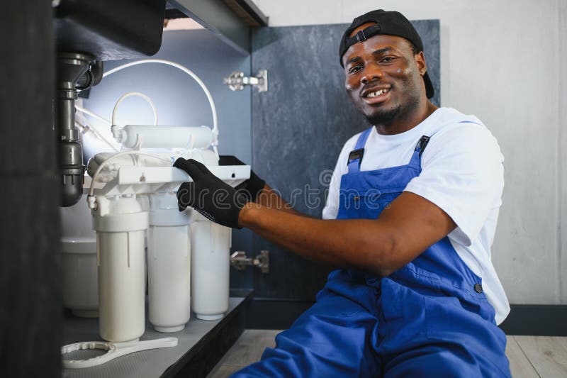 African American Plumber Change the Water Filter. Stock Photo - Image ...
