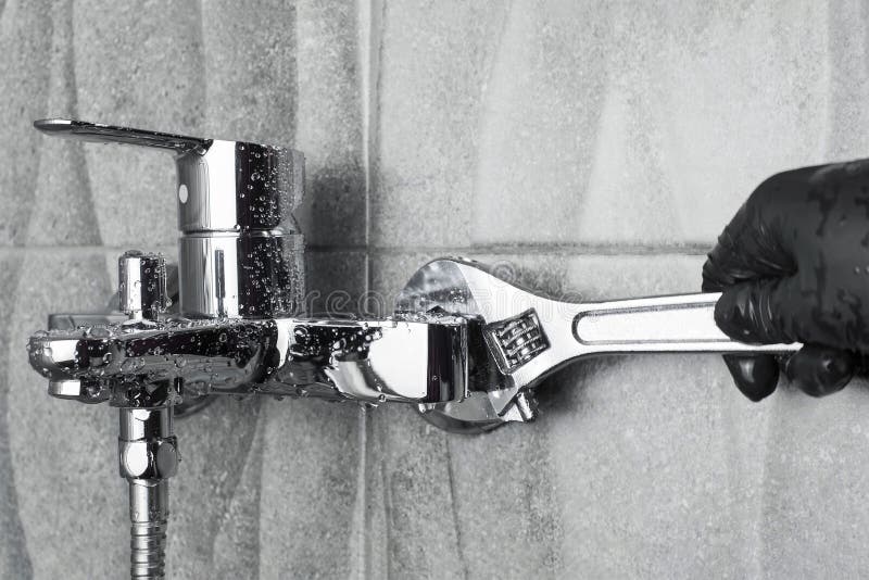 Plumber Fixing a Leaking Tap Faucet Using an Adjustable Wrench, Do-it ...