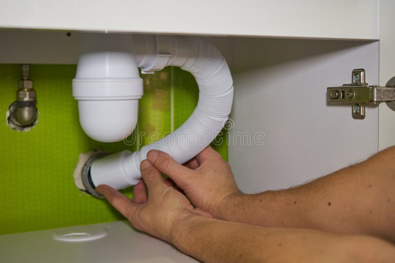 A Plumber Installs a Siphon for a Wash Basin,the Hands of a Plumber ...