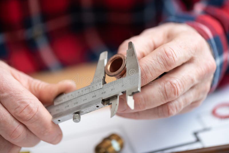Plumber using a caliper stock photo. Image of concept - 175036334