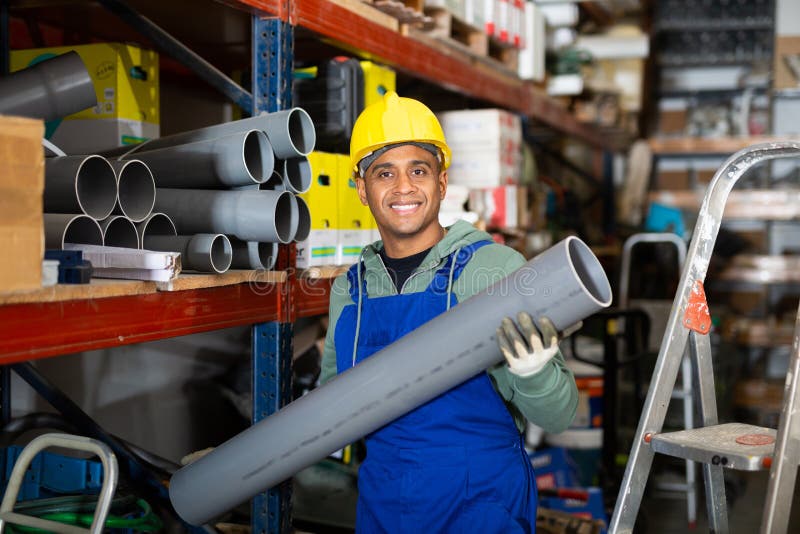 Plumber in Protective Helmet and Overalls Selects Plastic Pipes in ...