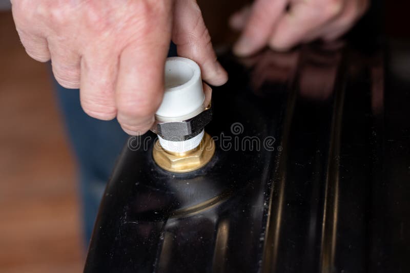 A Plumber Screws an Adapter for a Polypropylene Pipe To a Water Tank ...