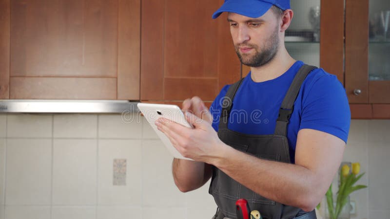 Plumber Wearing a Tool Belt with Various Tools Using Tablet during Work ...