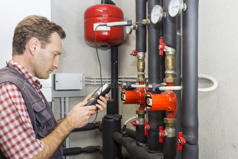 Plumber at Work Measures the Temperature in a Boiler Room Stock Photo ...