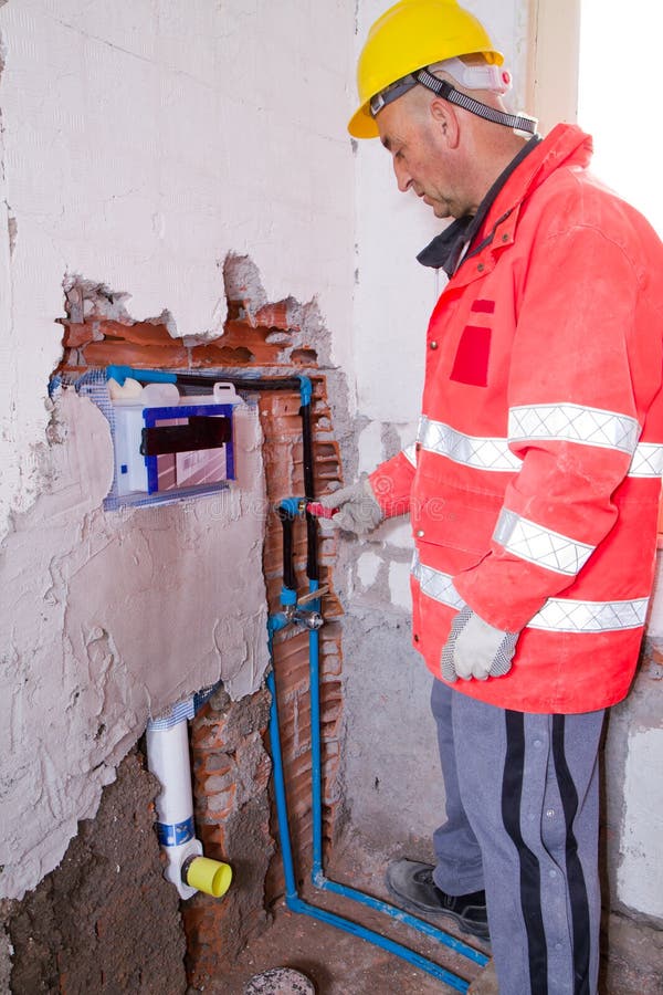 Plumber at work in a site stock image. Image of mason - 67901045