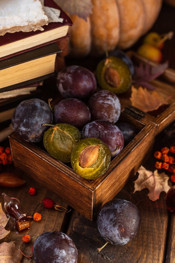 Plums in a Wooden Box. Two Halves of a Plum Cut in Half Lie Side by ...