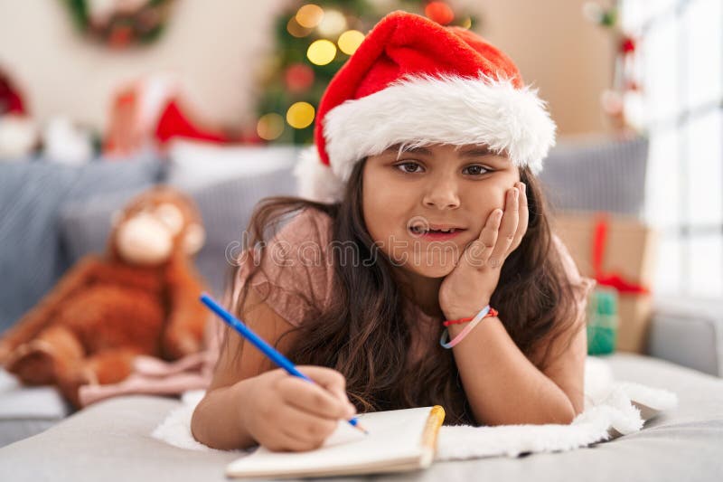 Plus Size Hispanic Girl Writing on Notebook Lying on Sofa by Christmas ...