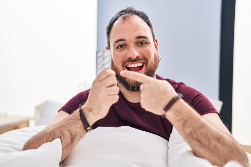 Plus Size Hispanic Man with Beard in the Bed Holding Pills Smiling ...