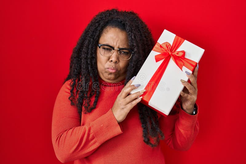 Plus Size Hispanic Woman Holding Gift Depressed and Worry for Distress ...