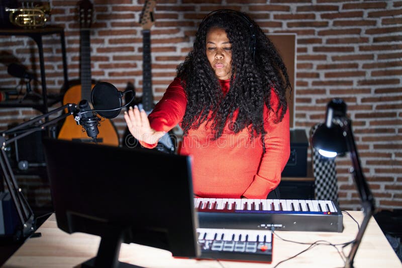 Plus Size Hispanic Woman Playing Piano at Music Studio Doing Stop Sing ...