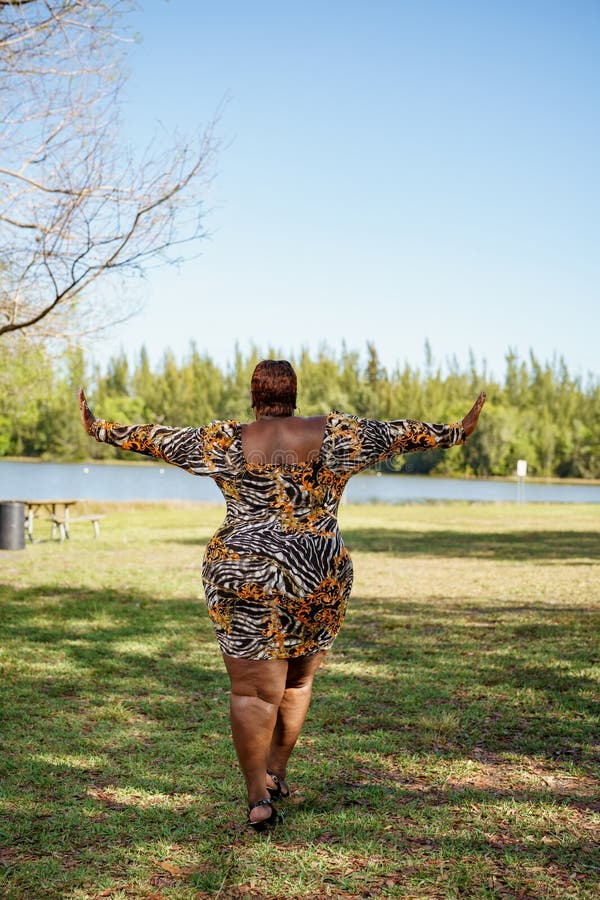 Plus Size Model Facing Away from Camera with Arms Outstretched. Park ...