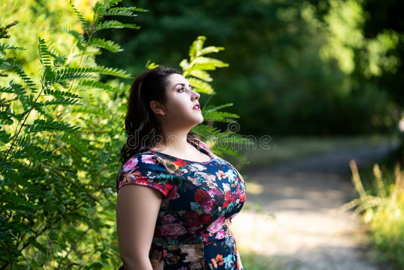 Plus Size Fashion Model In Blue Dress With A Deep Neckline Outdoors