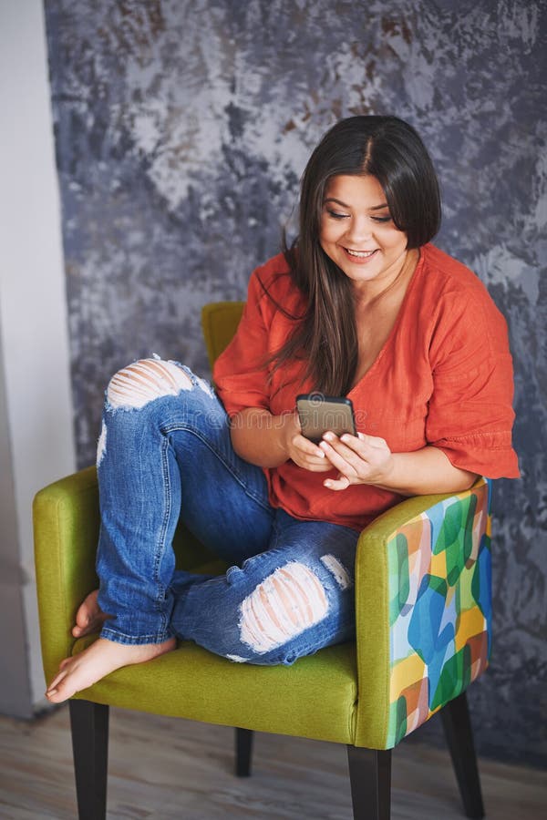 Plus Size Model Sitting on the Chair and Using Smartphone Stock Image ...