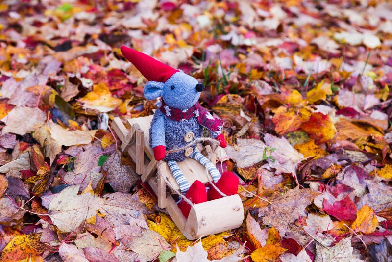 Plush Toy Mouse on Sled Sliding Down Colourful Mound of Leaves in the ...