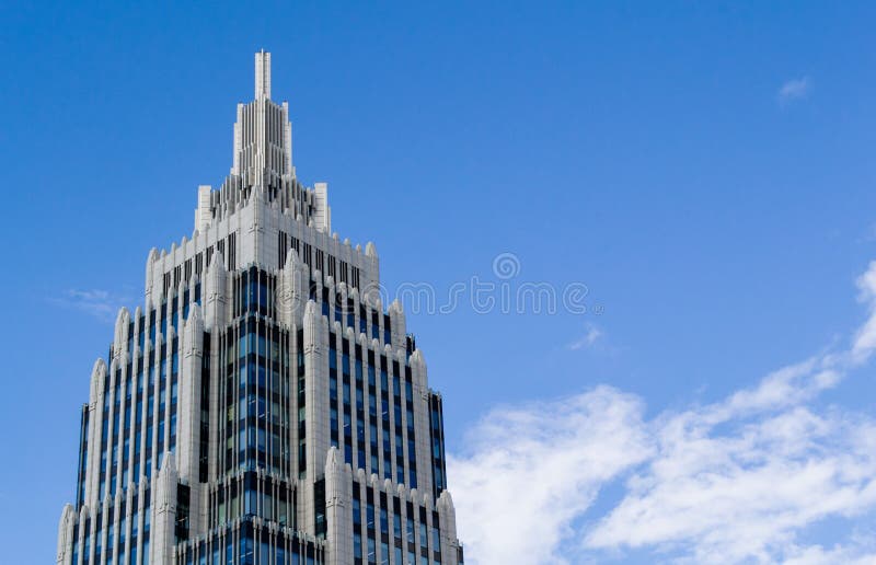 A Pointed Tower of an Office Building Against a Blue Sky with Clouds ...