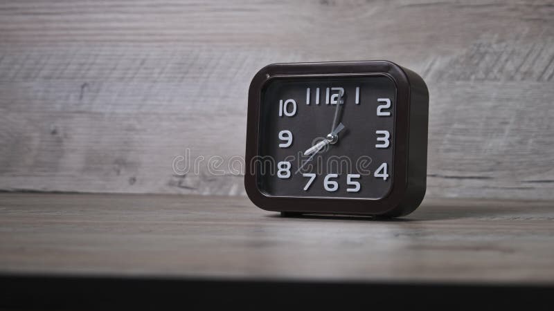 The Pointer Clock on a Wooden Table Shows the Time Stock Footage ...